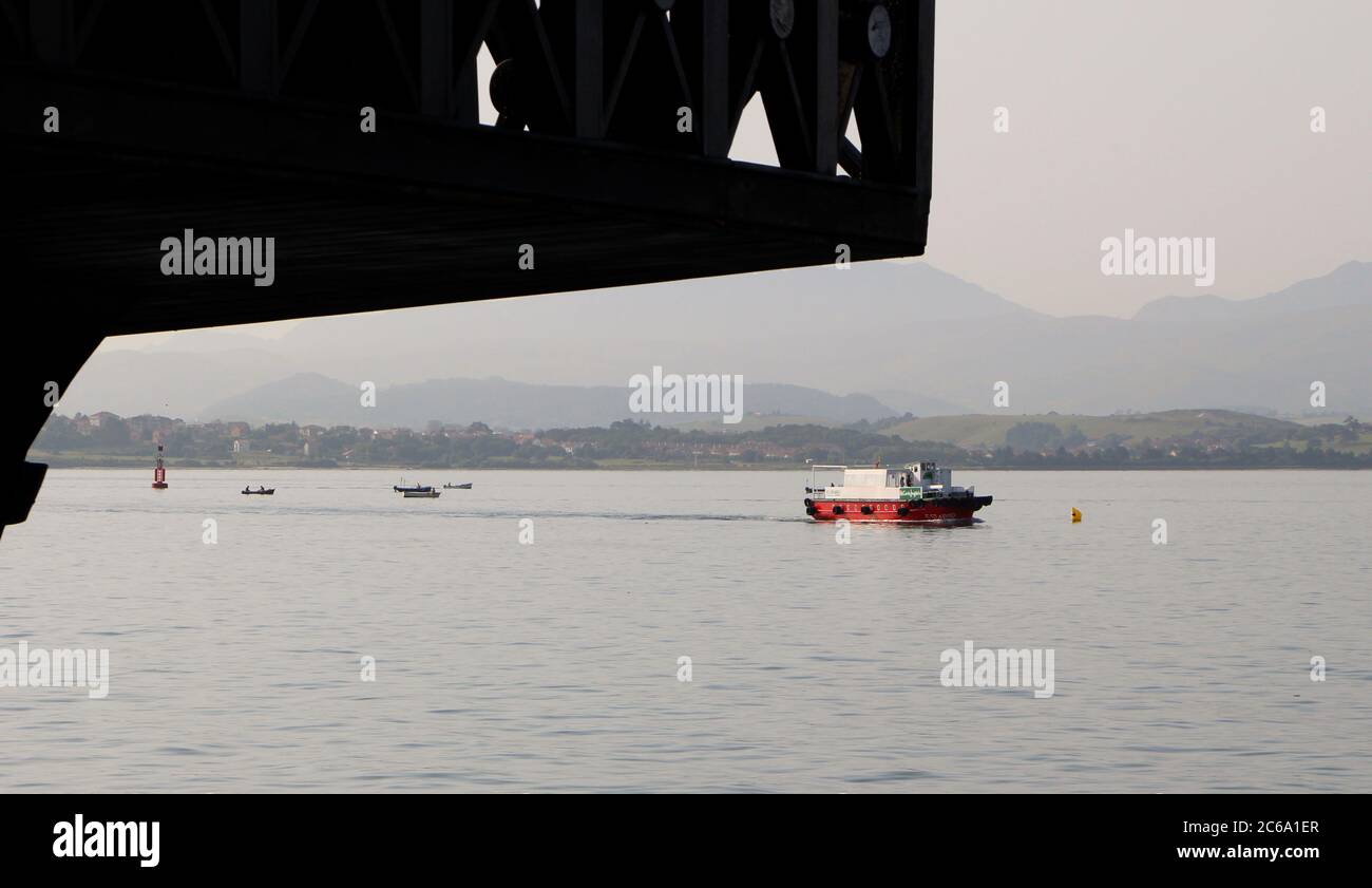 View of a ferry boat with the stern of the replica of the Victoria ship ...