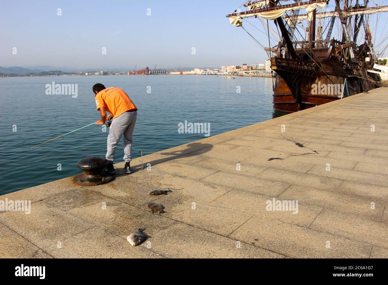 Fishing in front of the replica of the Victoria ship a carrack and the ...