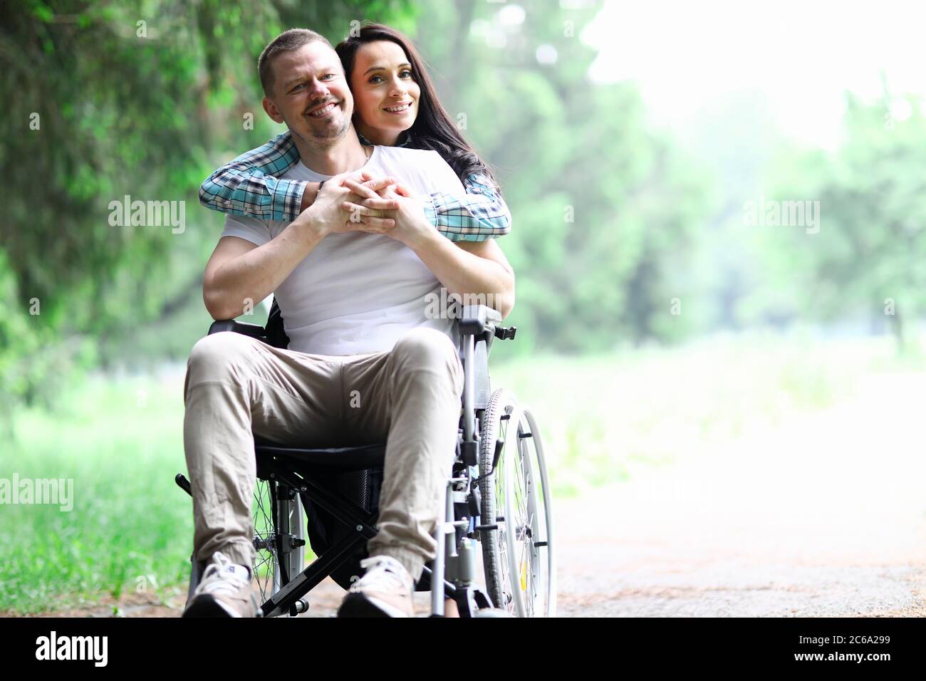 Woman hugs man in wheelchair Stock Photo - Alamy