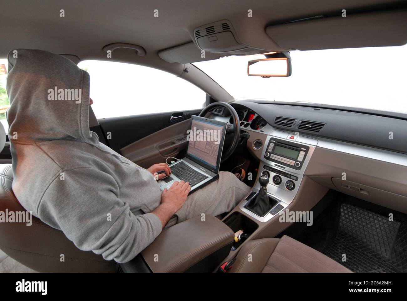 car computer crime, Man stealing data from a laptop sitting in a car ...