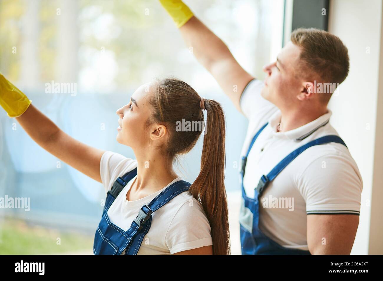 Side view on hardworking workers of cleaning company washing window in ...