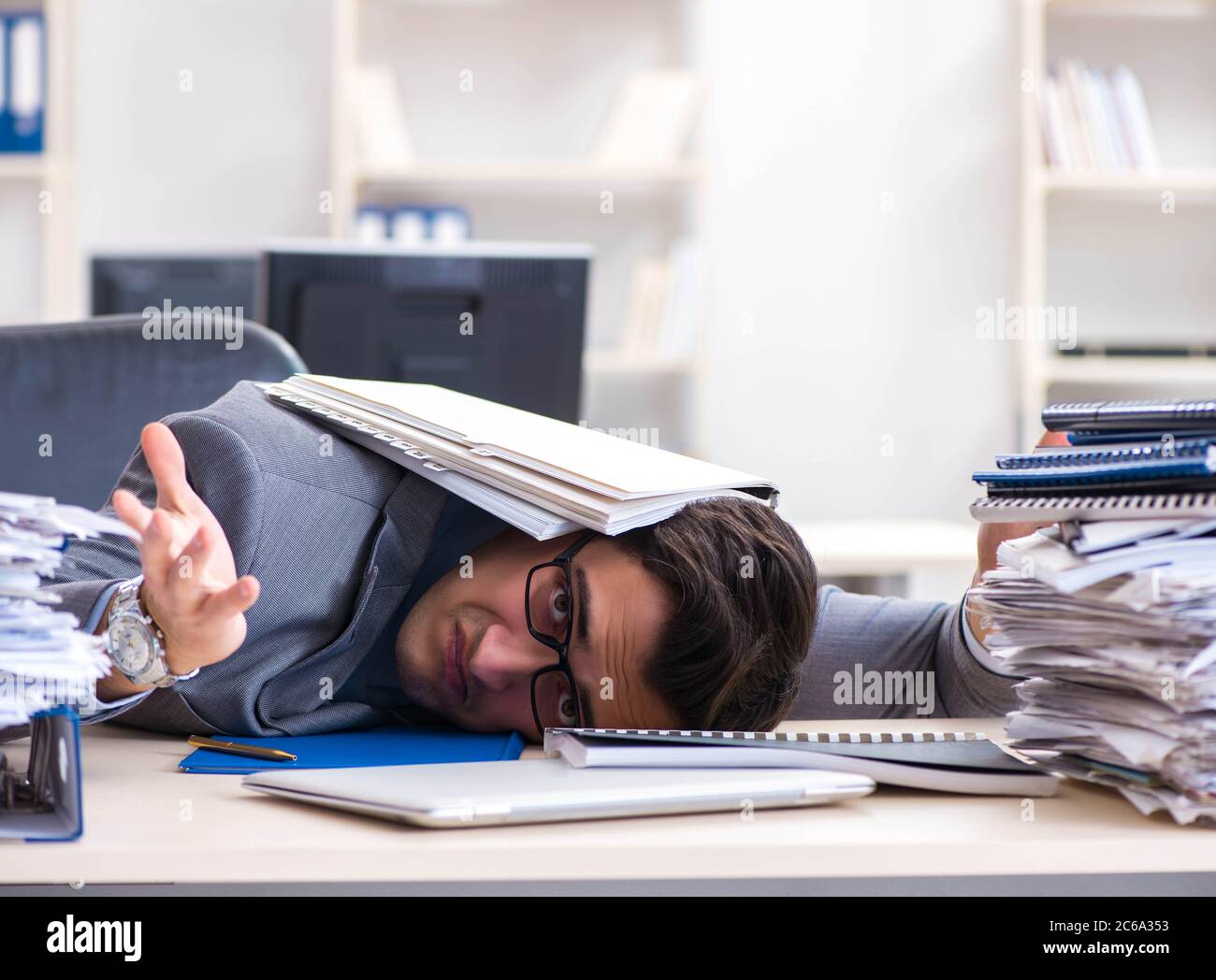 The overloaded with work employee under paperwork burden Stock Photo ...