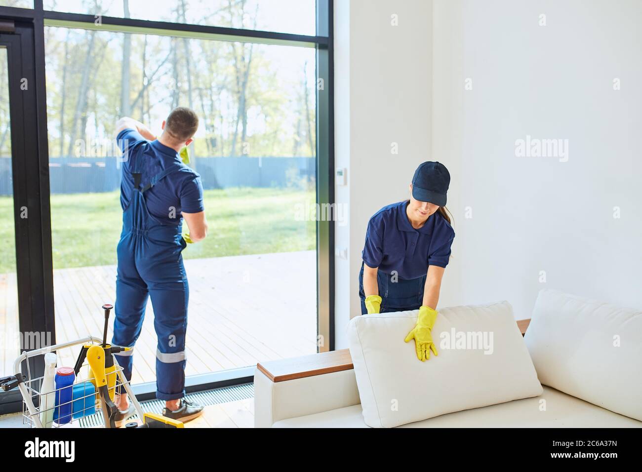 Young janitors invited from cleaning company to clean new house. Two ...