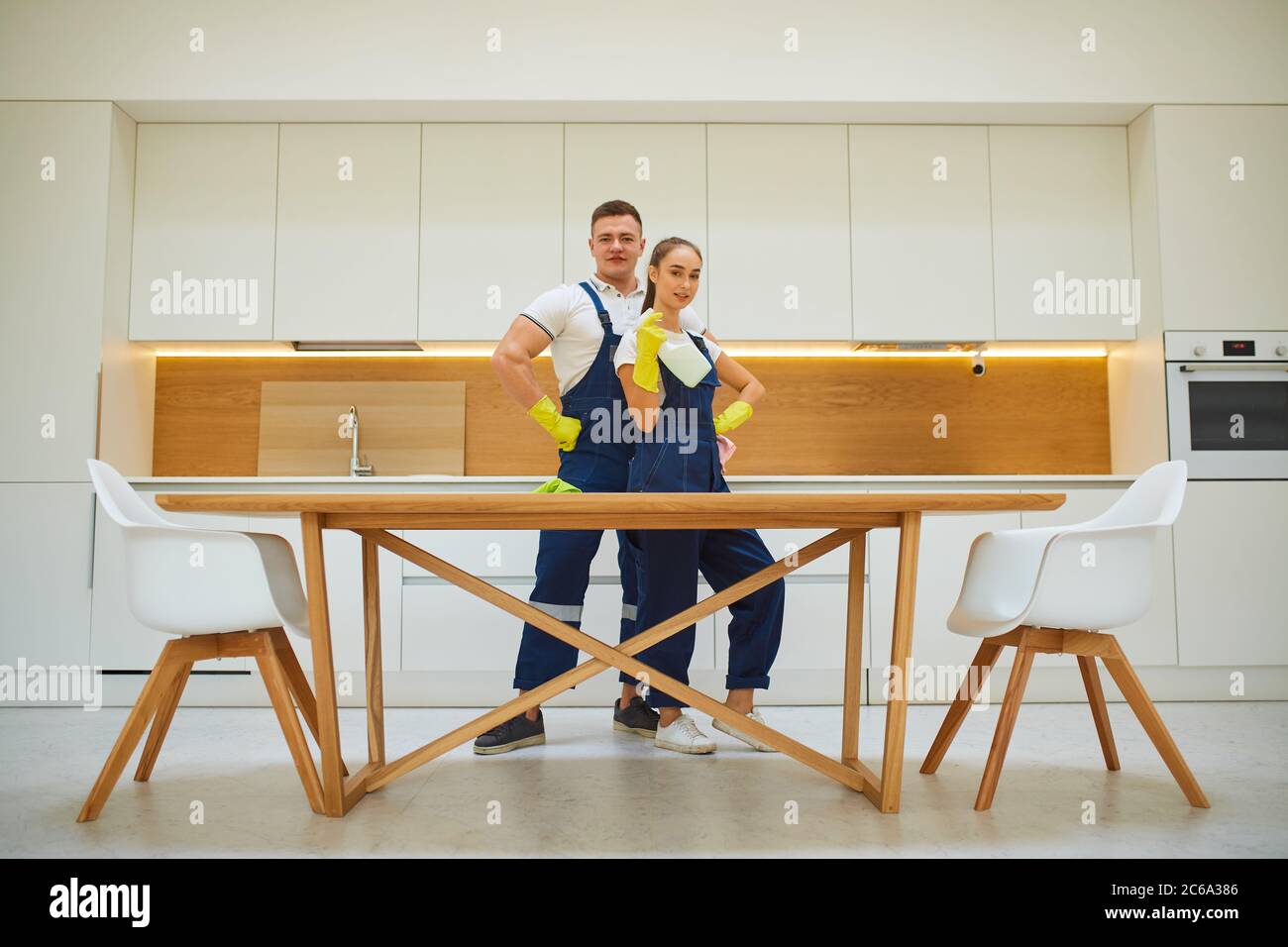 Two co-workers of cleaning company, man and woman stand together after ...