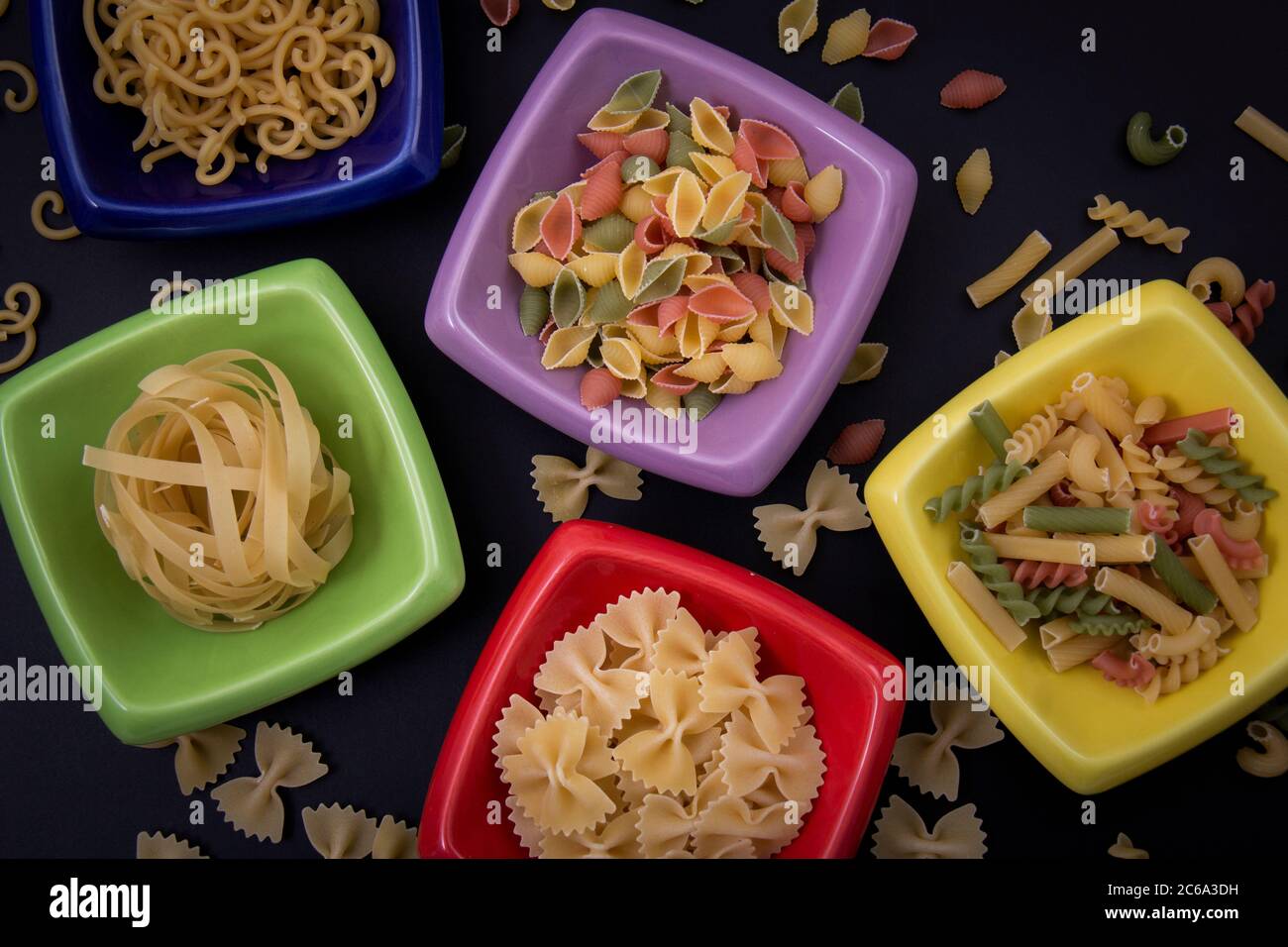 Shaped and colorful pasta in different sizes and colors in small dishes ...