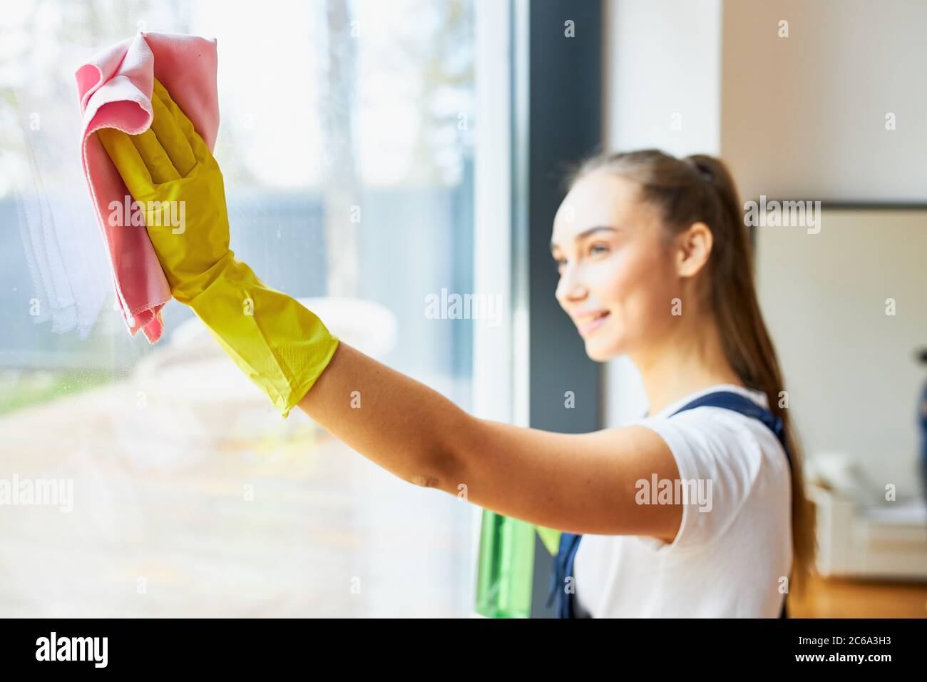 Industrious woman with rug, wearing yellow rubber gloves do cleaning of ...