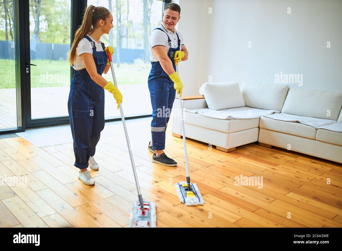 Teamwork of professional janitors in uniform working together washing ...