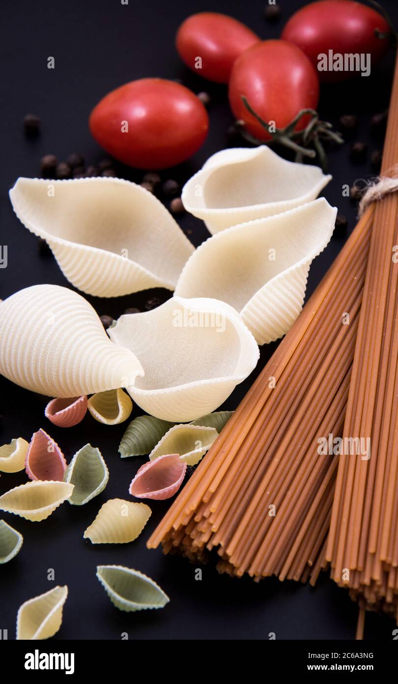 Shaped pasta and plain pasta. Pasta in different shapes and colors with ...