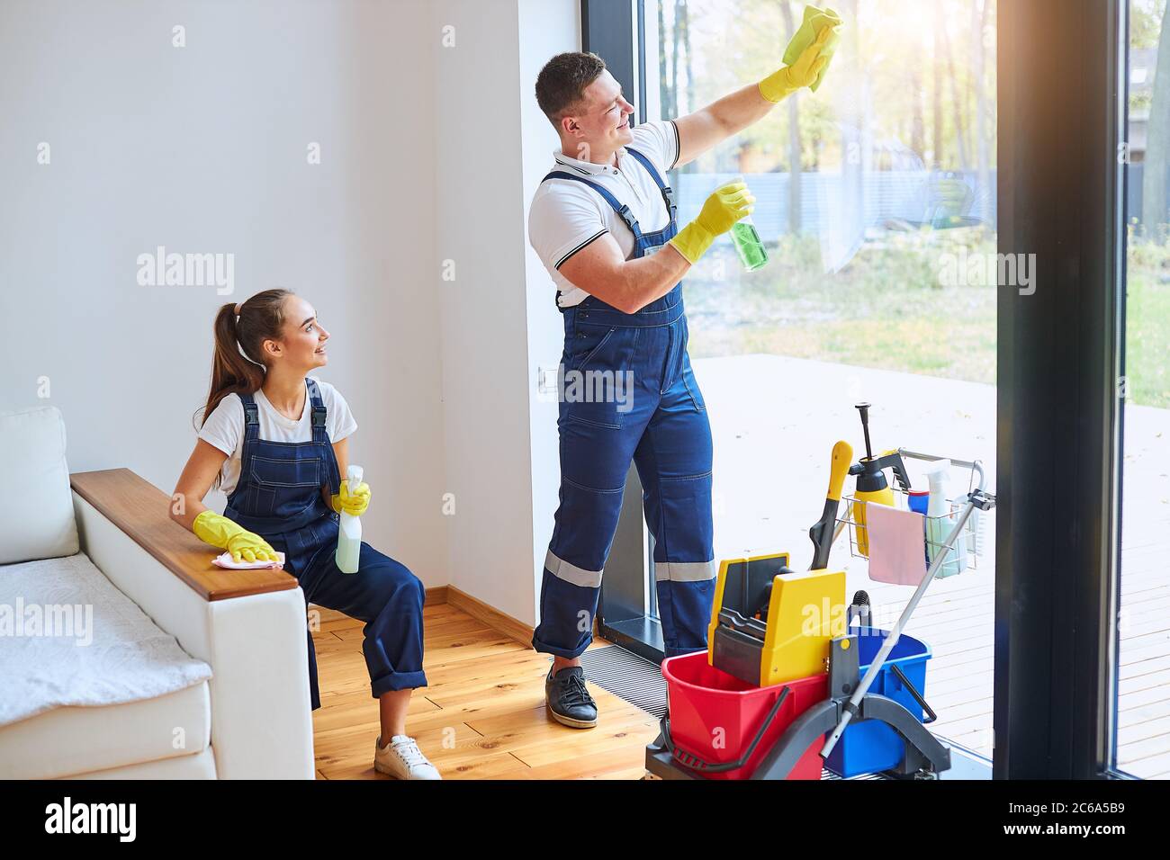 Collaboration of two neat cleaners during cleaning house. Happy work ...
