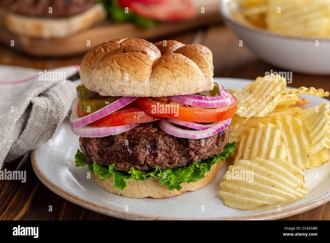 Juicy grilled hamberger with lettuce, tomato, pickle and onions on ...