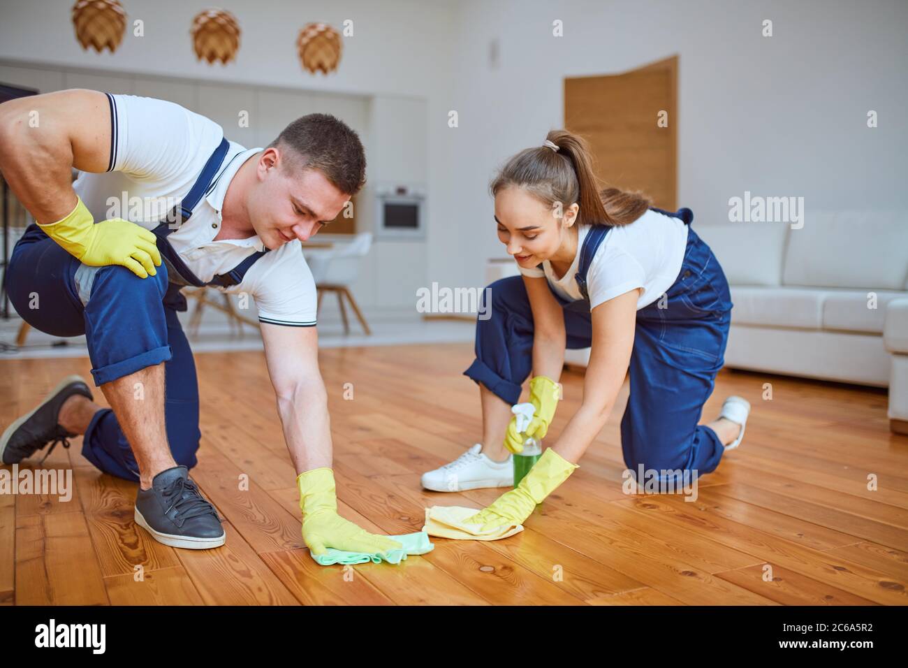 Young team staff of cleaning service washing wooden florr with rag ...