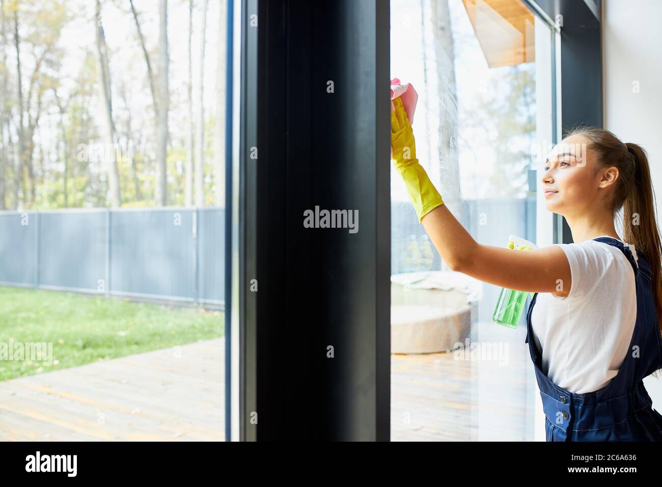 Industrious woman with rug, wearing yellow rubber gloves do cleaning of ...
