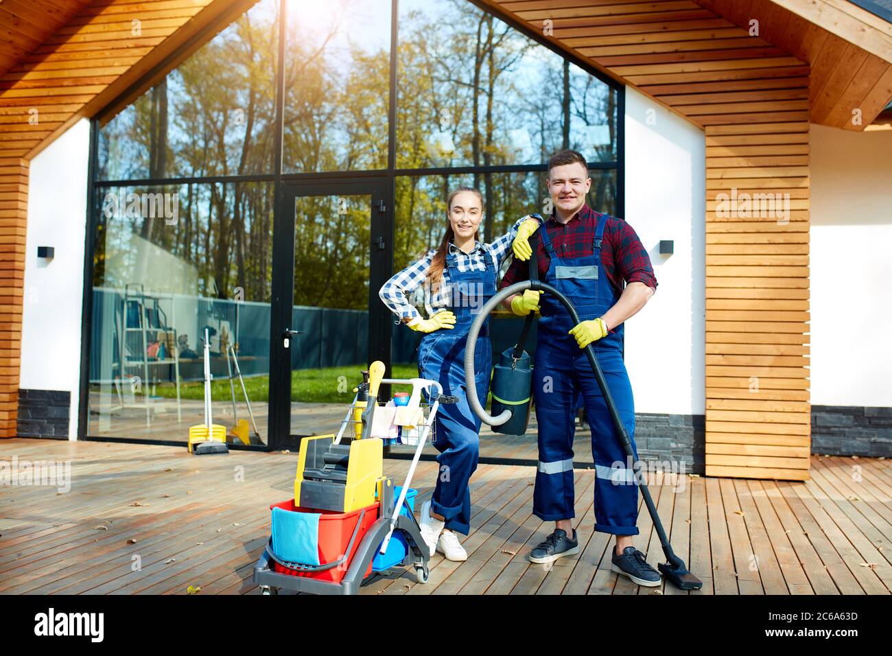 Young caucasian cleaners from cleaning service posing holding ...