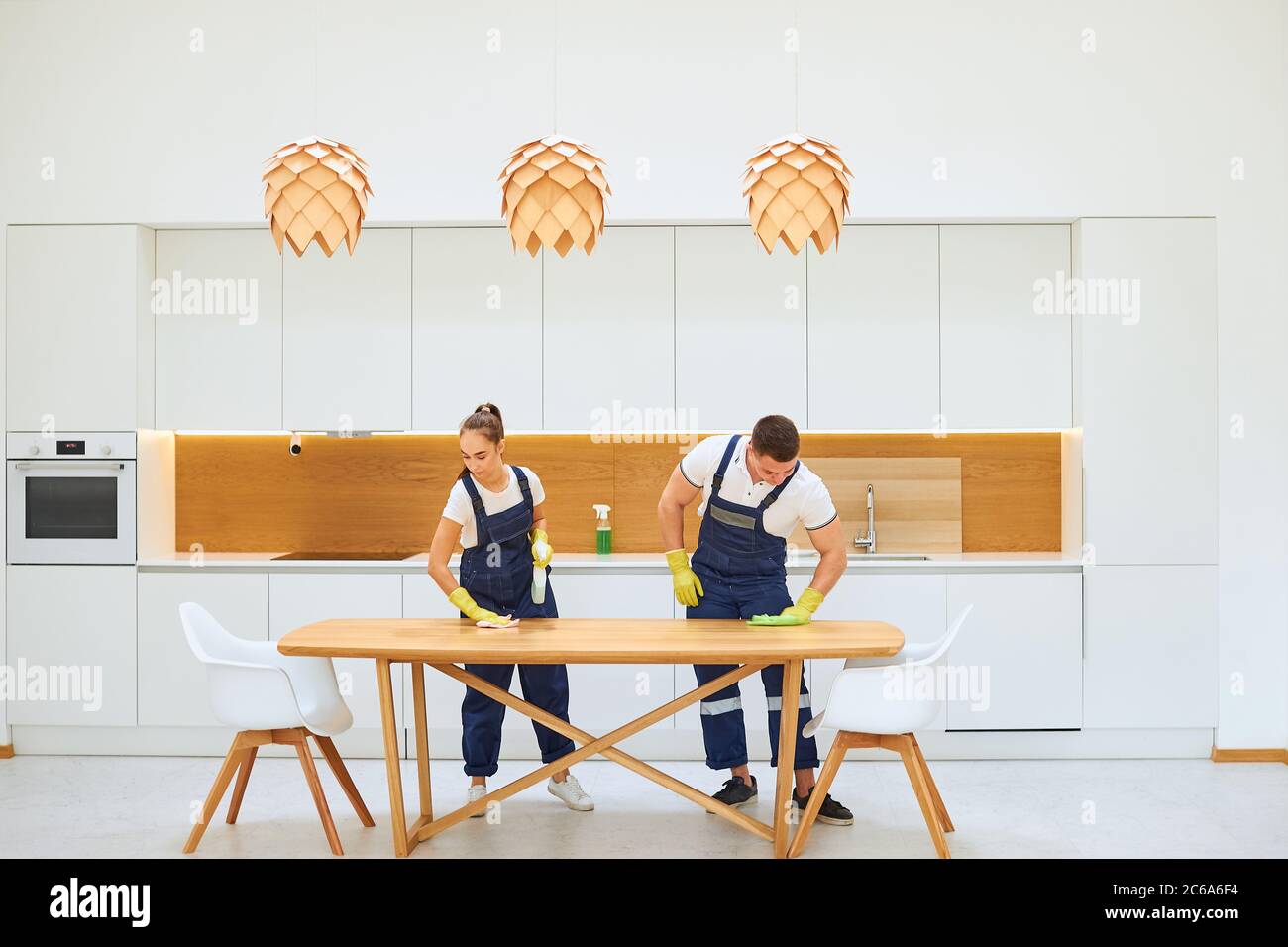 Cleaning service wiping kitchen table, white european interior of ...