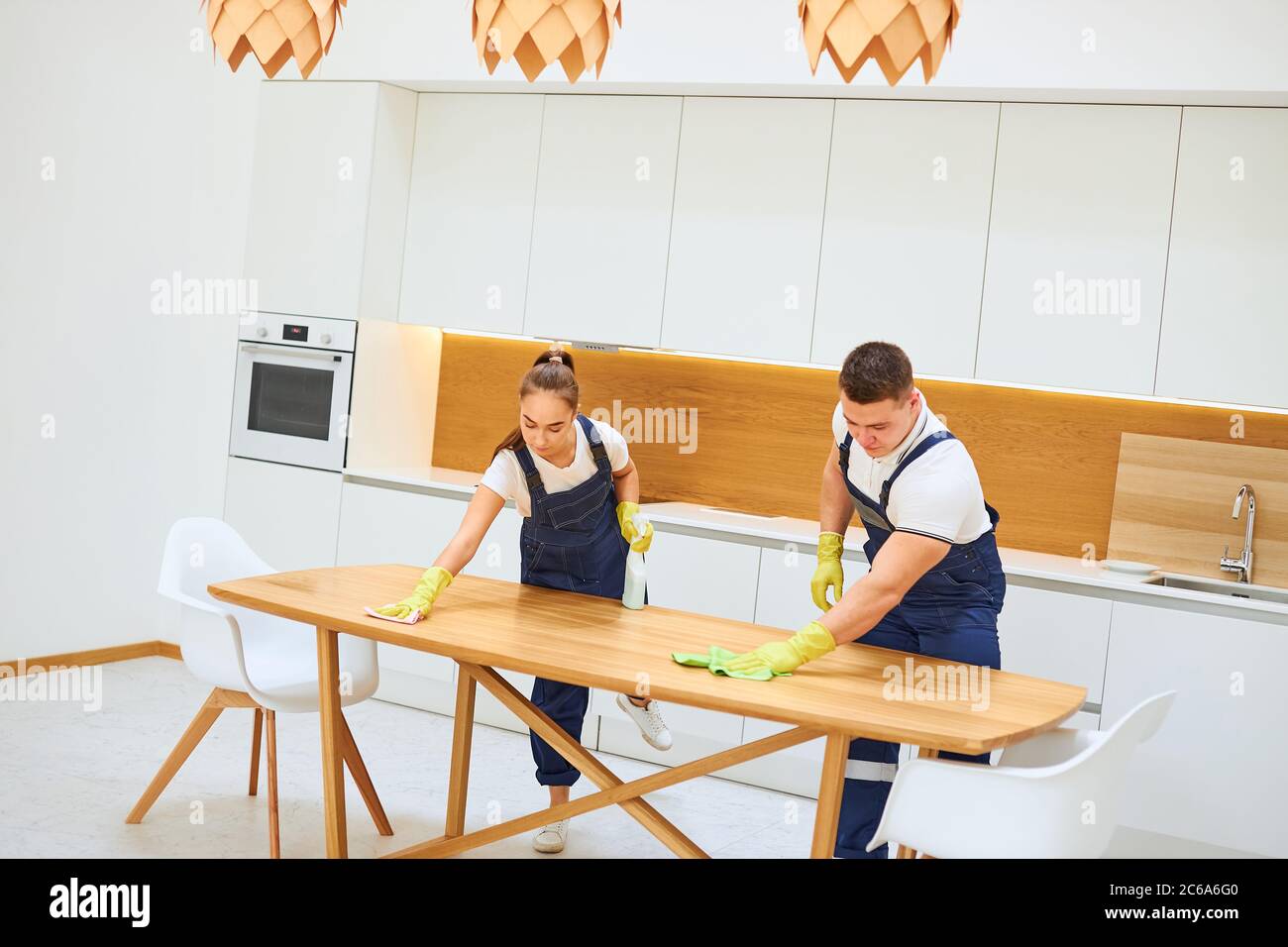 Cleaning service wiping kitchen table, white european interior of ...