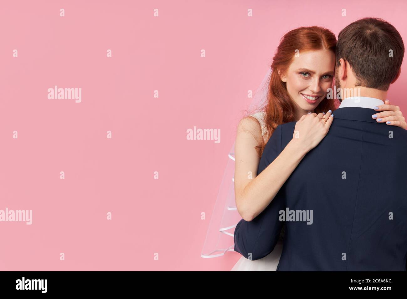 Back view on man in suit with her beautiful bride hugging him. Portrait ...
