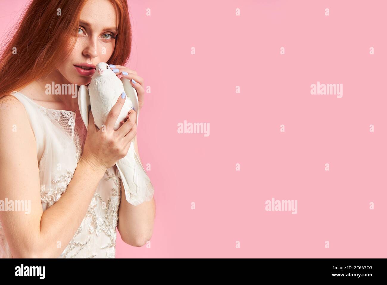 Portrait of young new-married caucasian lady bride hold white dove in ...