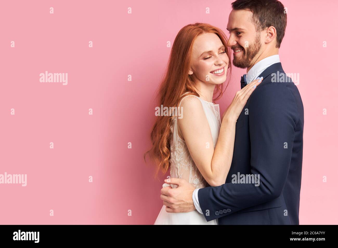 Handsome man in tuxedo and woman in white wedding dress lovely hug each ...