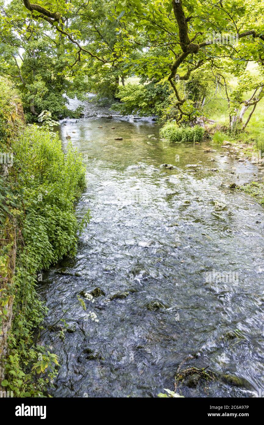 The River Dikler passing by the old mill in the Cotswold village of ...