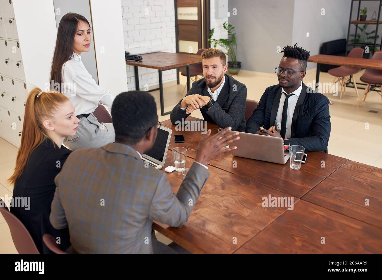 Handsome black man wearing tuxedo talking with busines colleagues ...