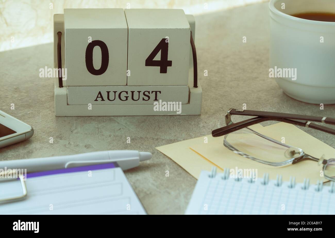 August 04, date on the calendar. Handmade wood cube with date month and ...