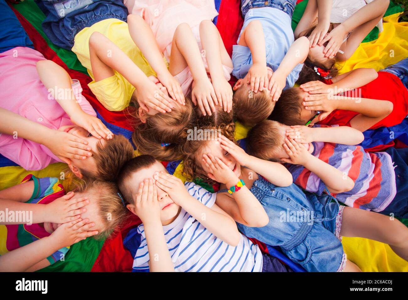Children laying very closely, covering face by hands Stock Photo - Alamy