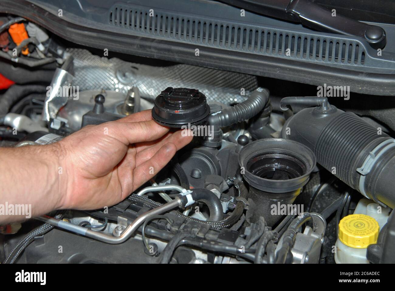 Repairman holding flap pouring oil into engine Stock Photo - Alamy
