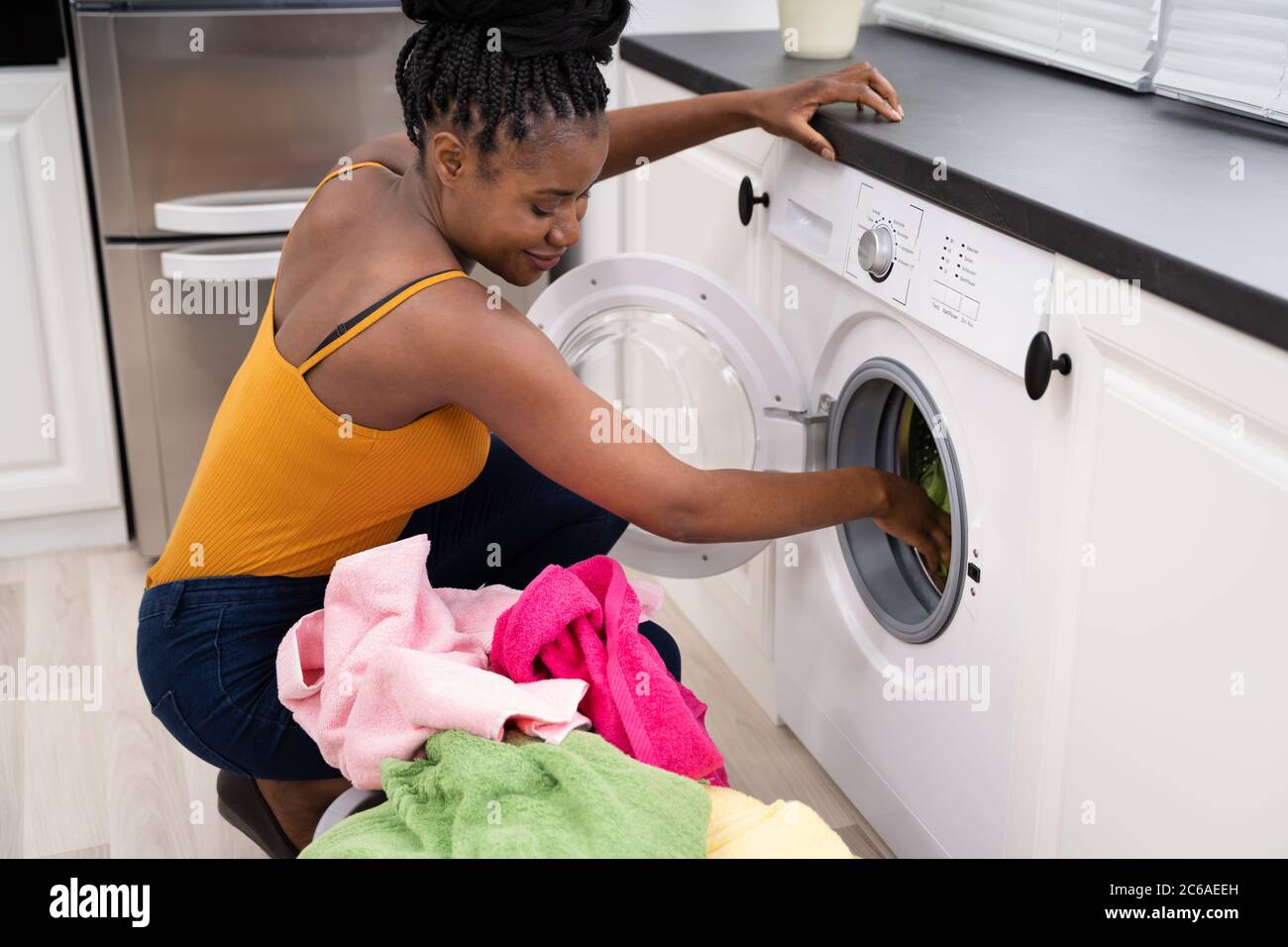 Woman Loading Dirty Clothes In Washing Machine For Washing In Utility ...