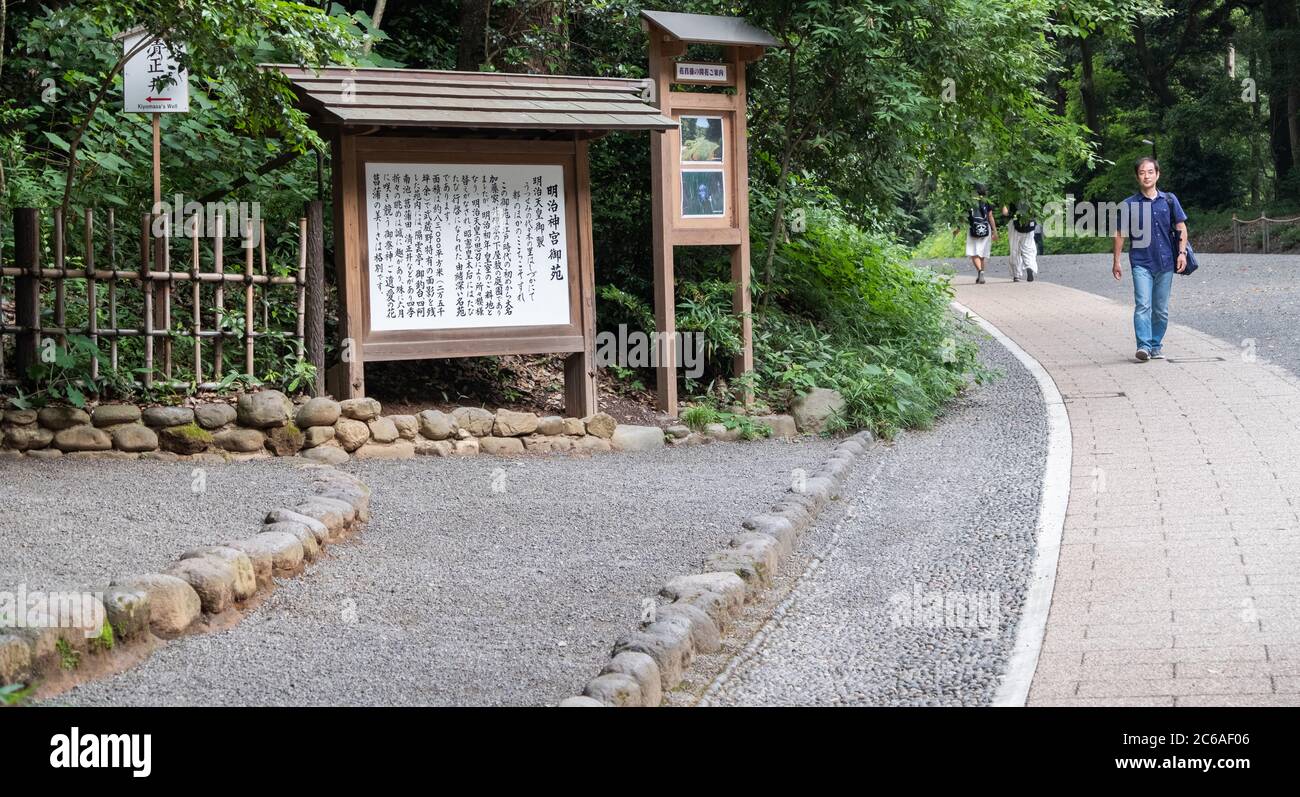 Tourist walking along the gravel path towards Meiji Jingu Shrine, Tokyo ...