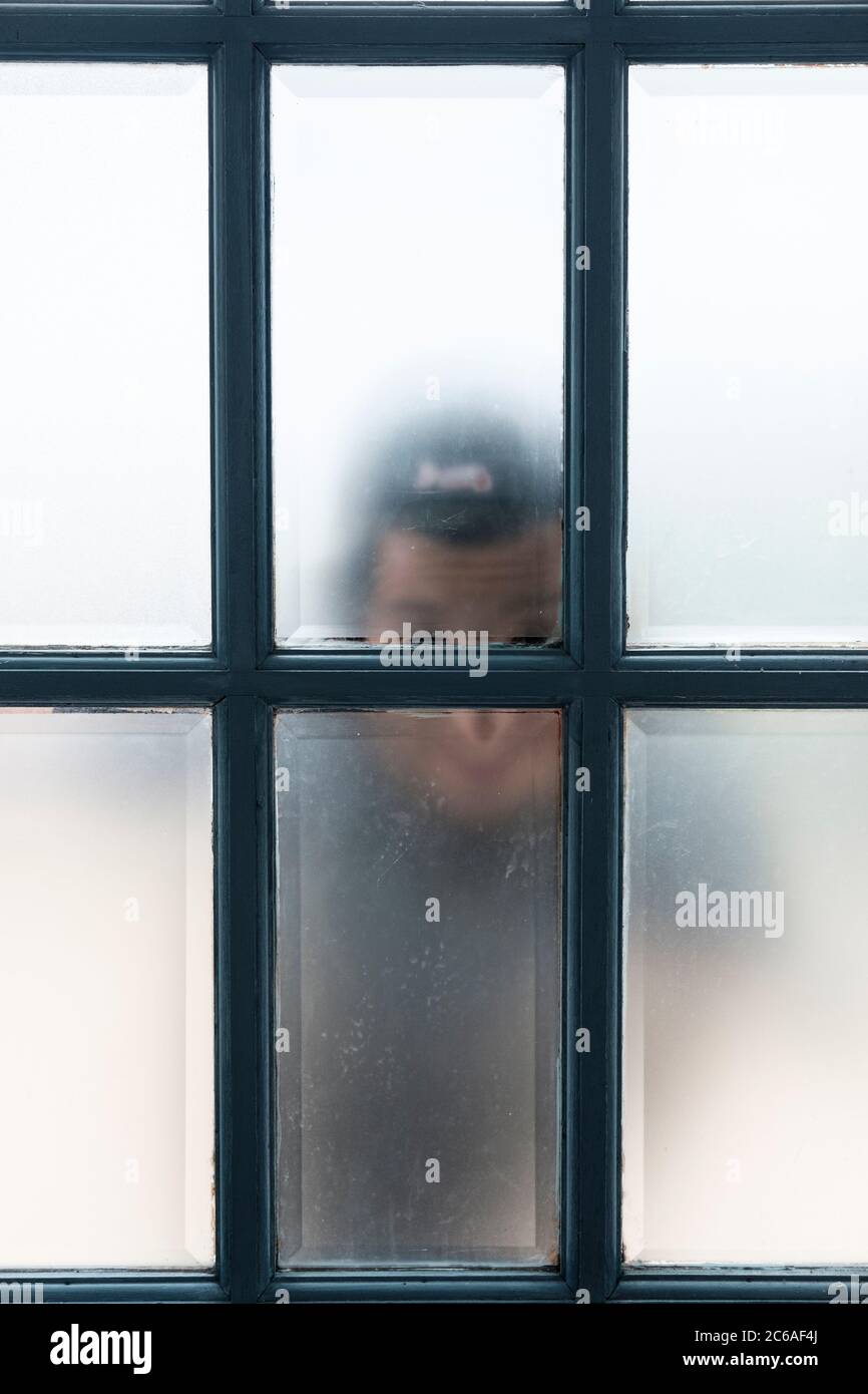 Boy looks through window in hi-res stock photography and images - Alamy