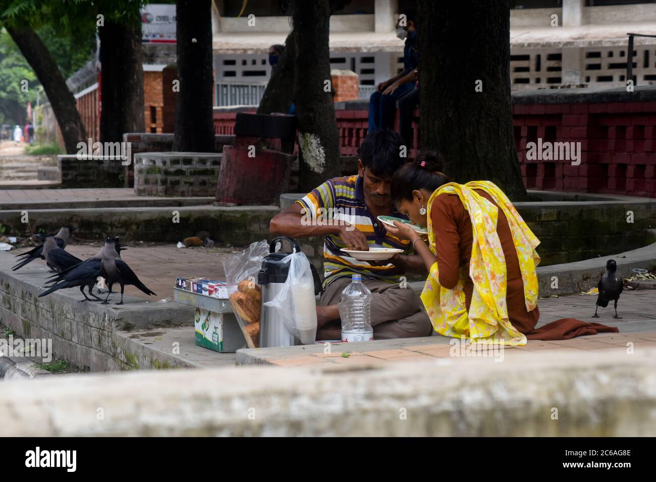 Homeless people eating food on the side of road during the coronavirus ...