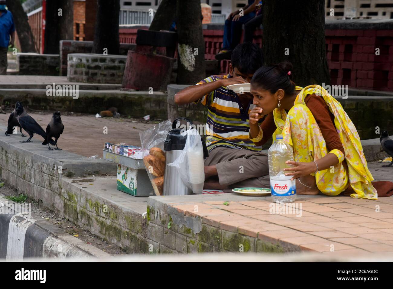 Homeless people eating food on the side of road during the coronavirus ...