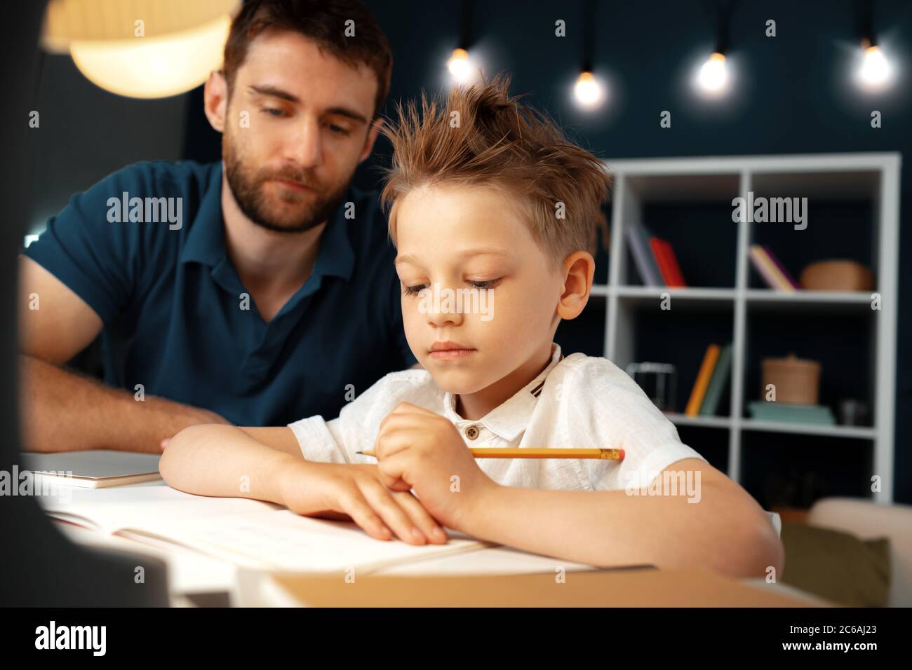 Dad and son doing school homework together Stock Photo - Alamy