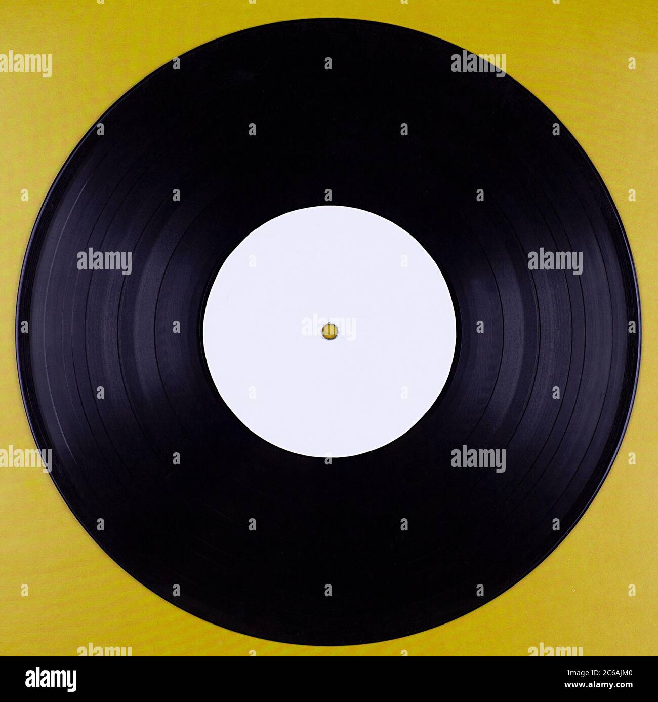 A vinyl record with an empty label isolated on a mustard-colored ...