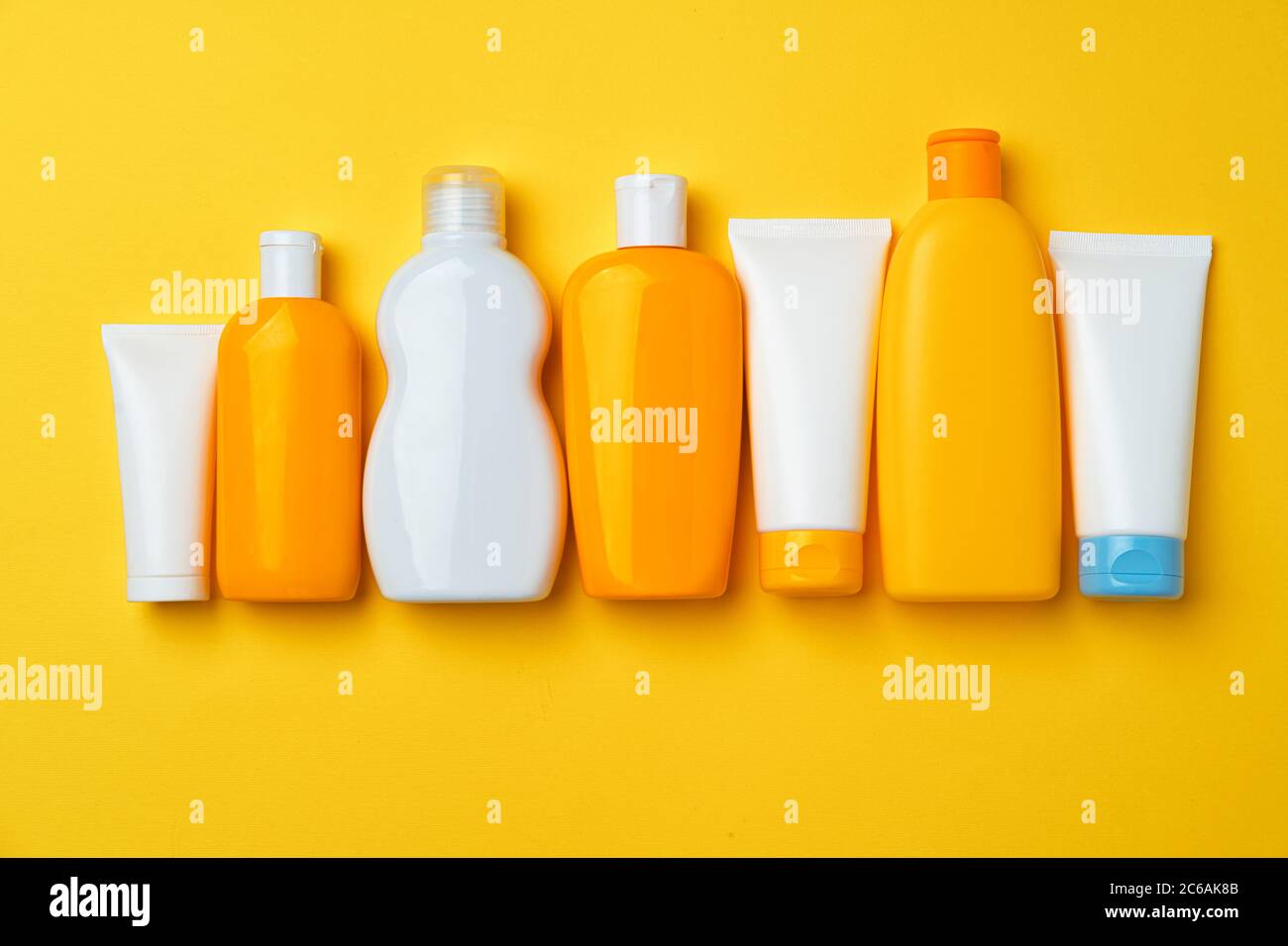 Collection of sunscreen cream bottles on yellow background Stock Photo ...