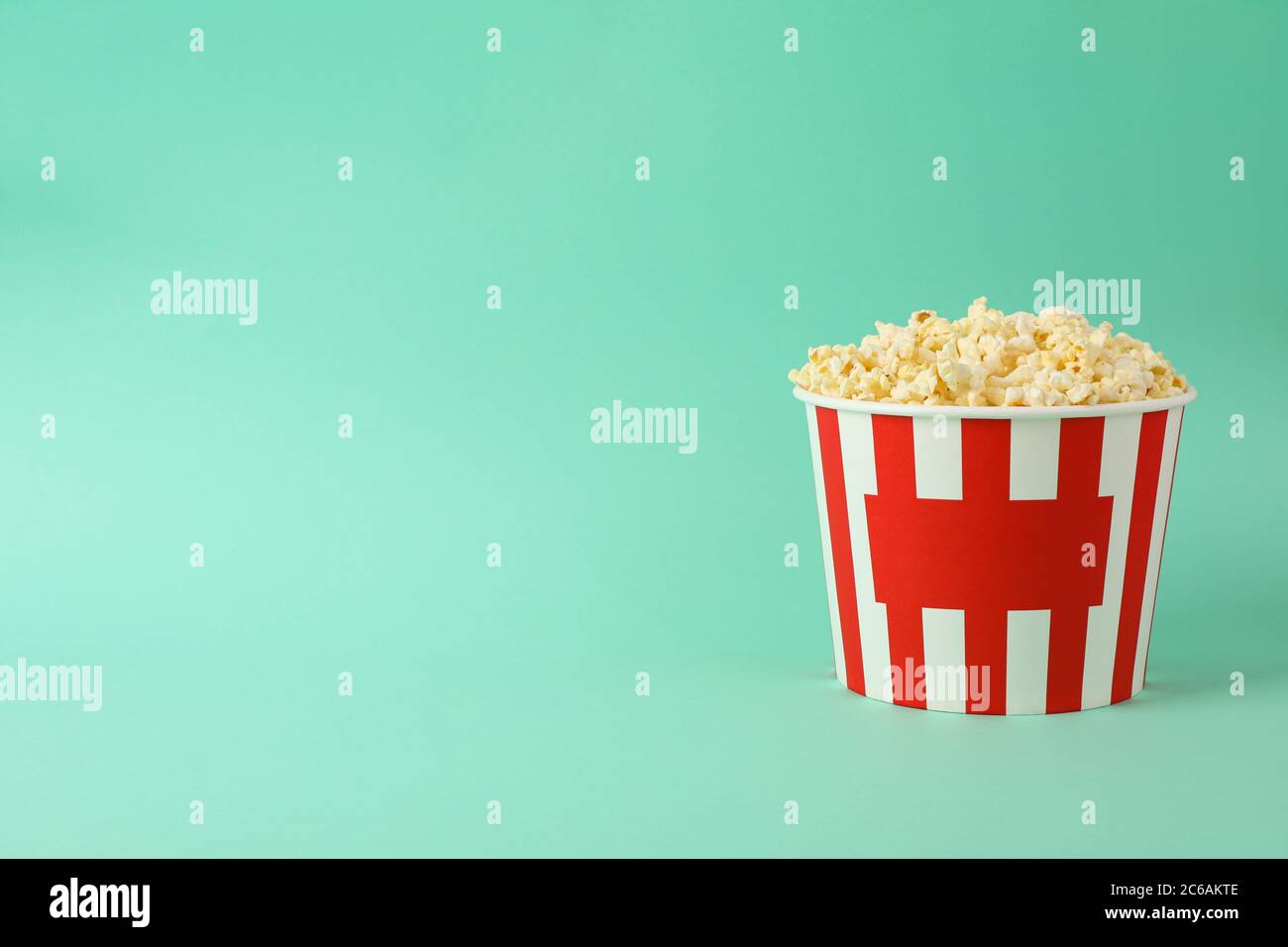 Cardboard bucket with tasty popcorn on mint background Stock Photo - Alamy