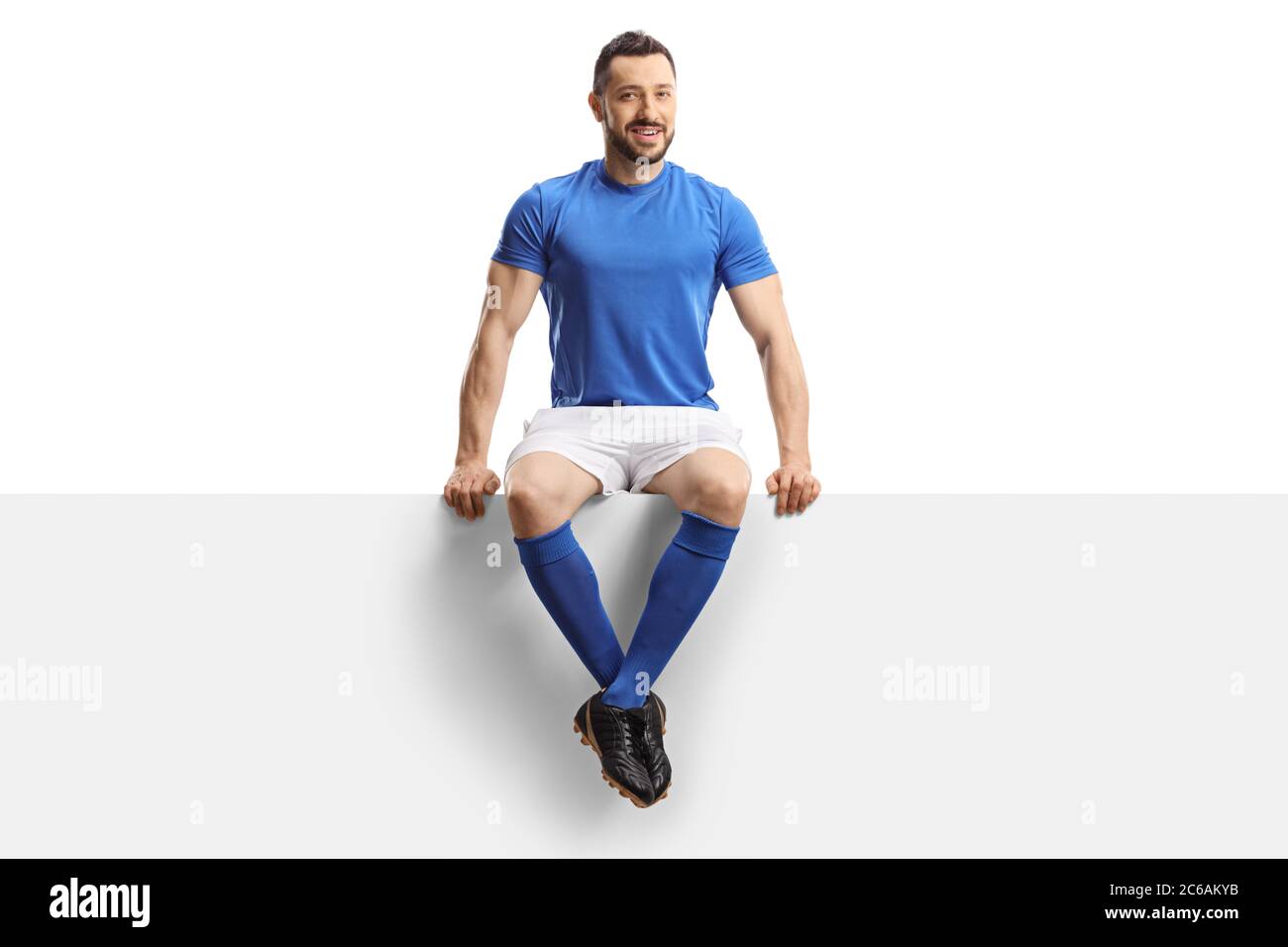 Soccer player sitting on a blank panel isolated on white background ...