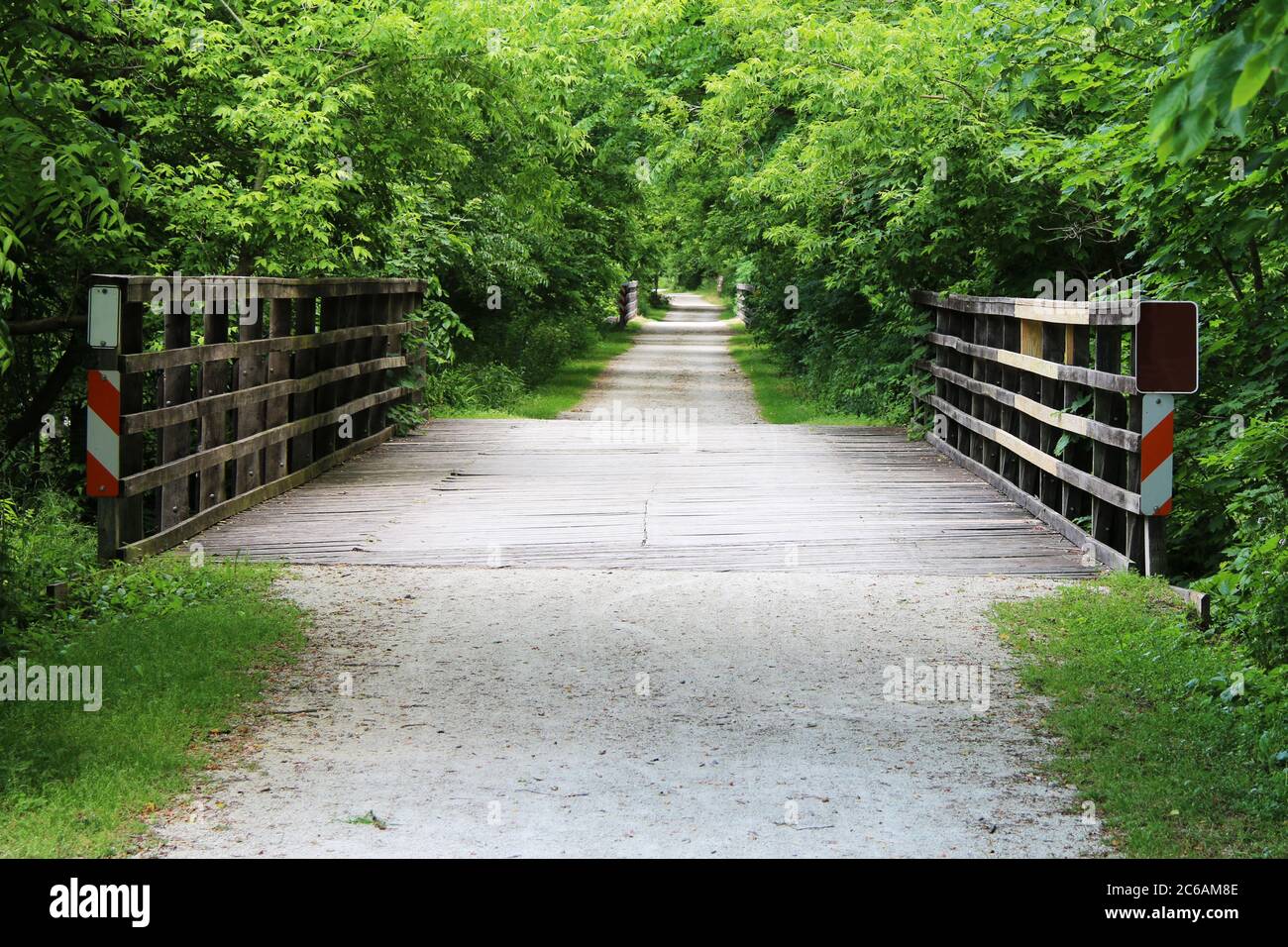 a dirt path over several bridges through the lush rural countryside ...