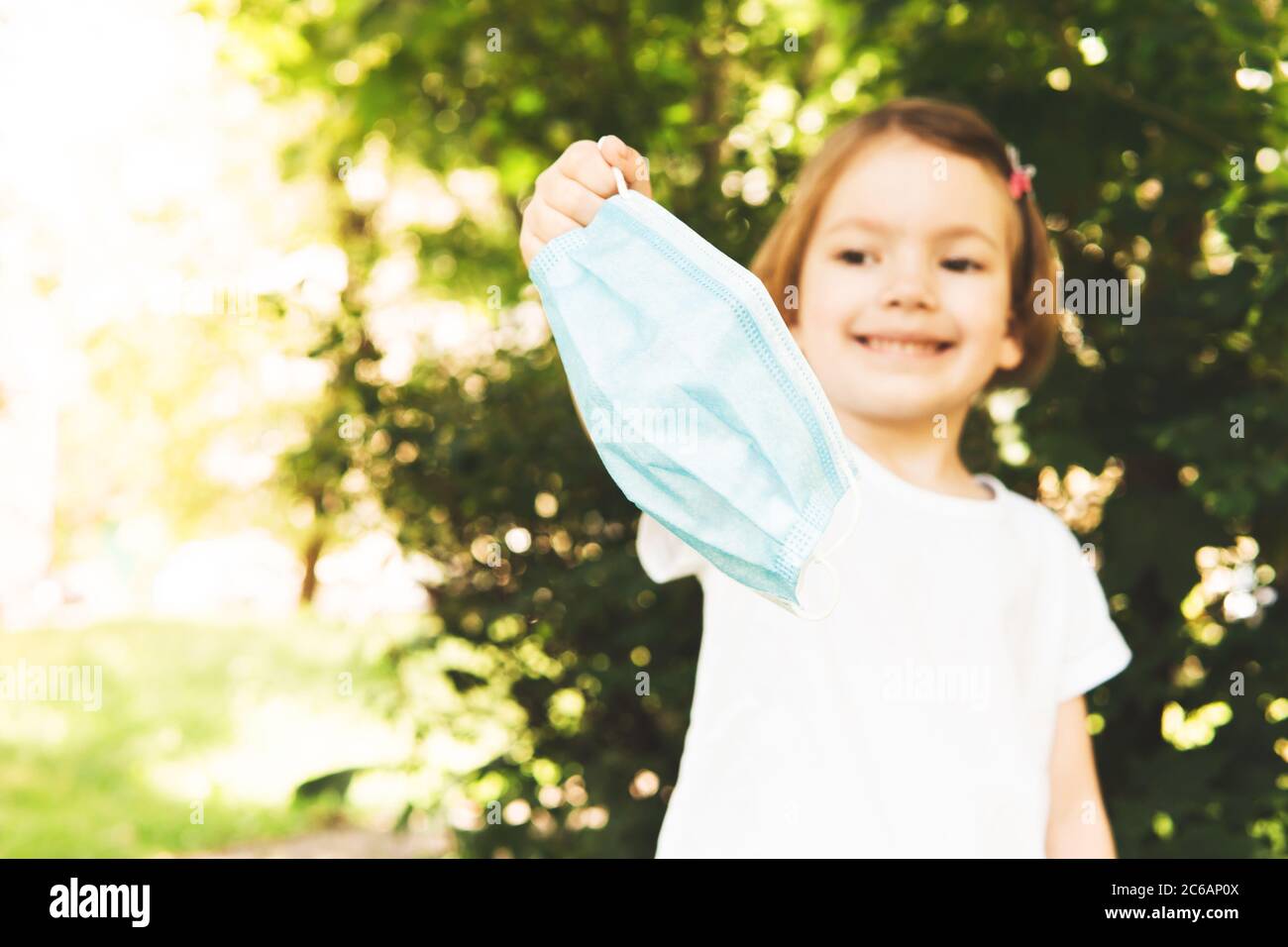 Little cute girl take off medical face mask with happy smile in the ...