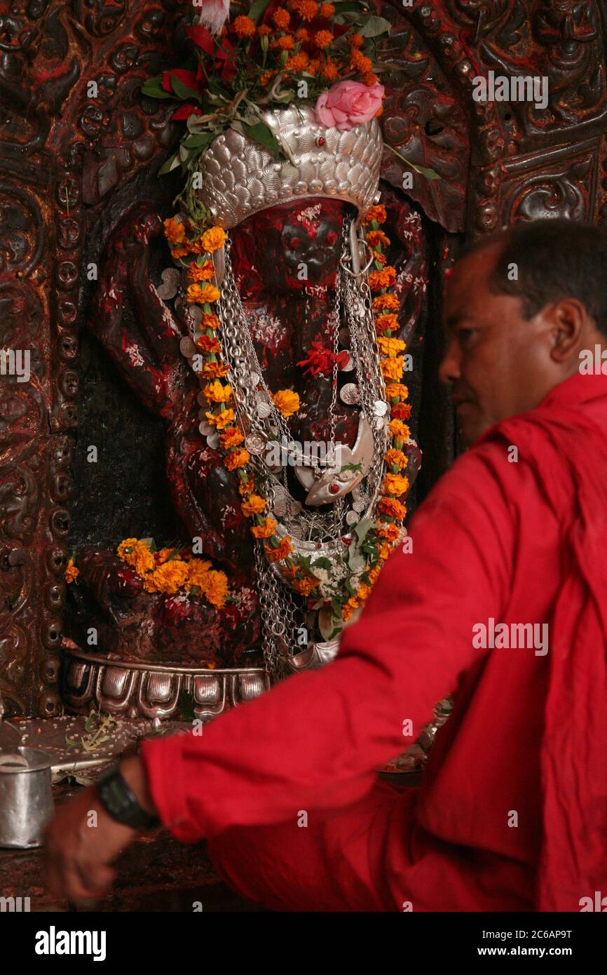High priest sits in front of the statue of the goddess Kali in the main ...
