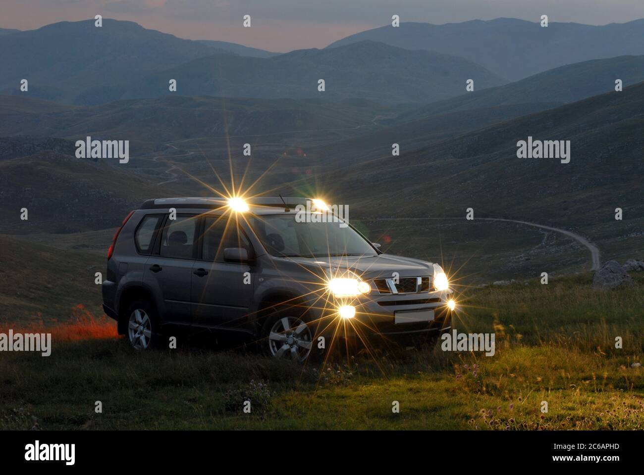 SUV on the mountain with the lights on Stock Photo - Alamy