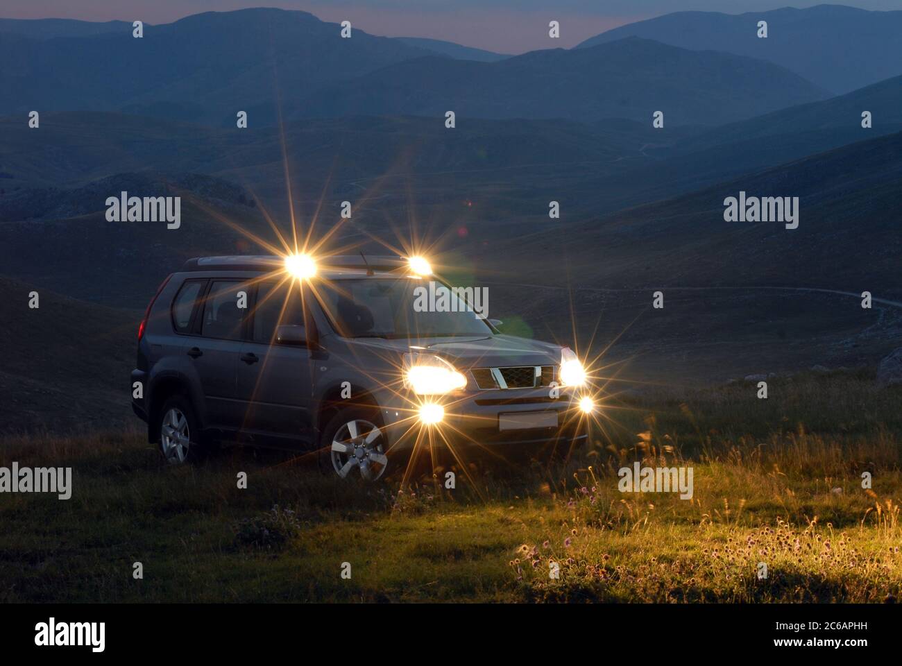 SUV on the mountain with the lights on Stock Photo - Alamy