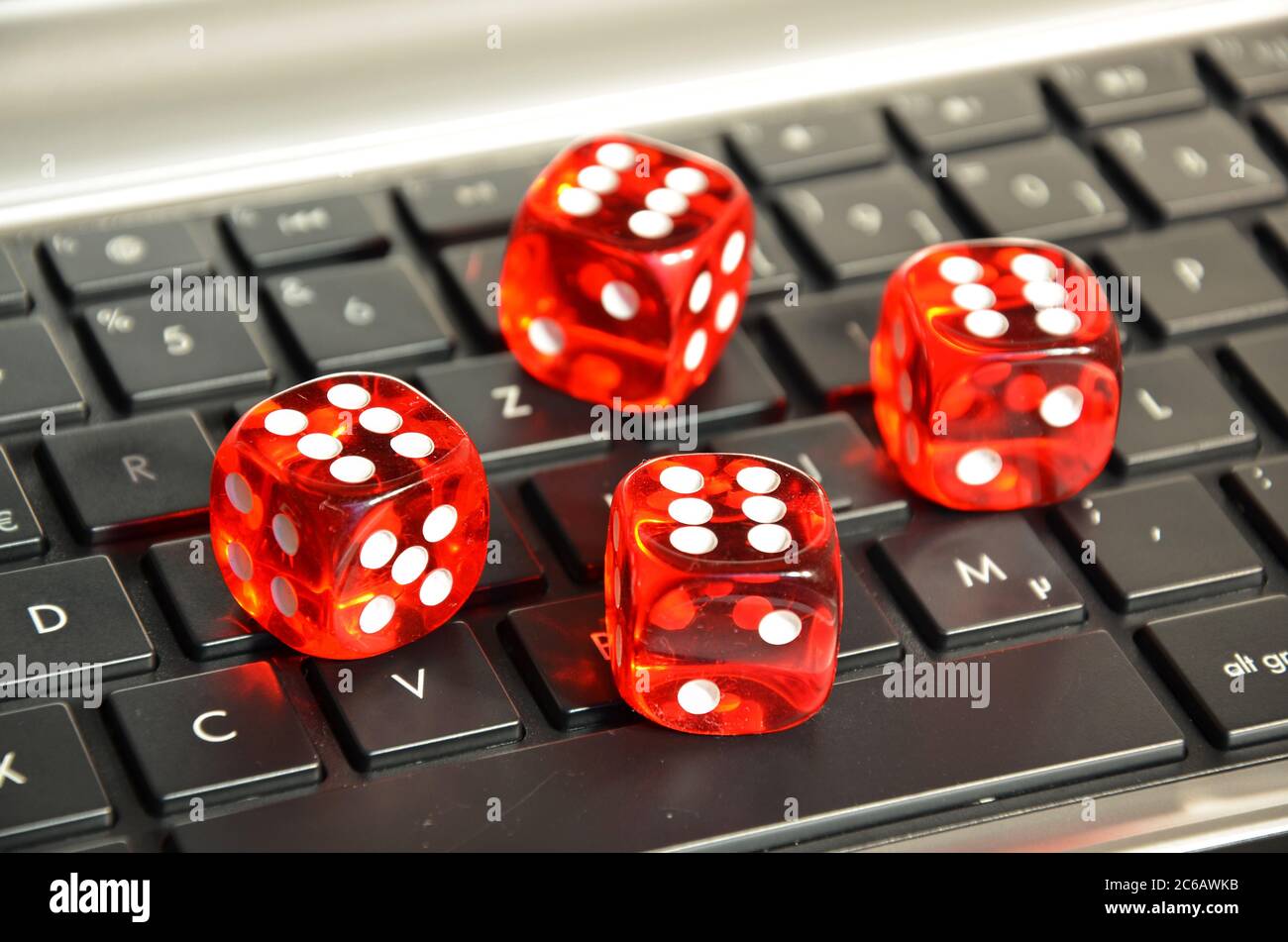 Red dice lying on computer keyboard Stock Photo - Alamy