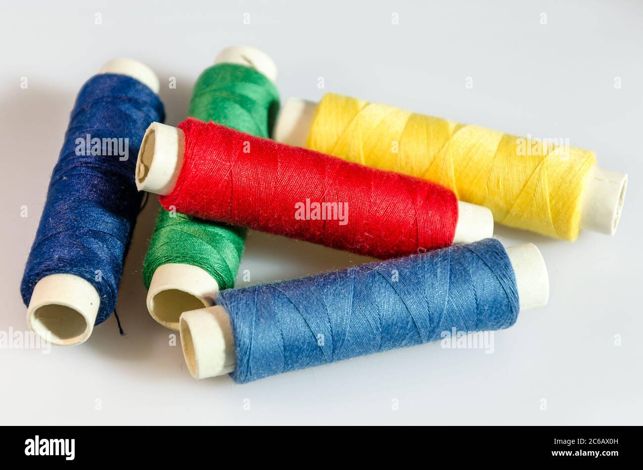 Colorful spools of yarn on white background Stock Photo - Alamy