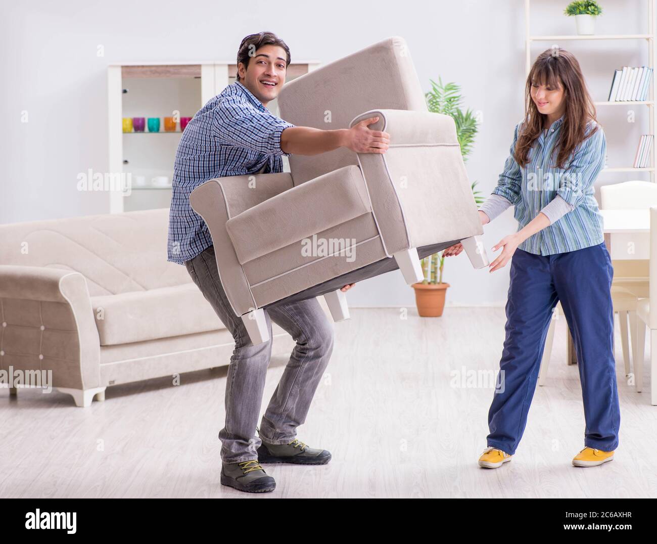 The man moving armchair in the living room Stock Photo - Alamy