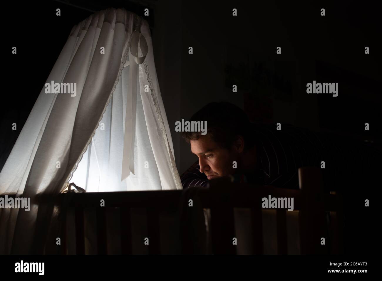 Young father with a loving expression on his face, looking into a ...