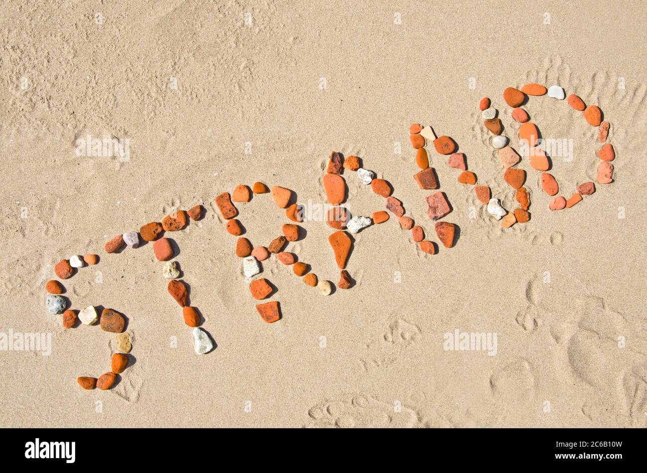 The word ‘Strand’ (beach) made of rocks at the beach (in German Stock ...