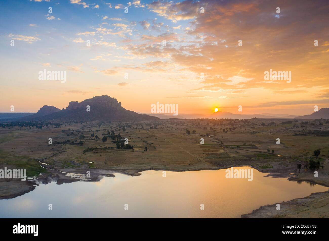 Sunrise lighting the small lake and Gheralta Mountains in background ...
