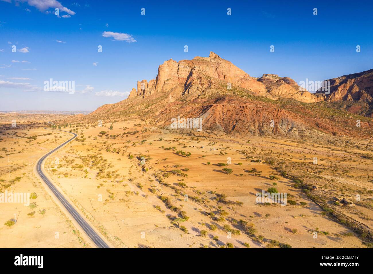 Road crossing the desert landscape of Gheralta Mountains at sunset ...