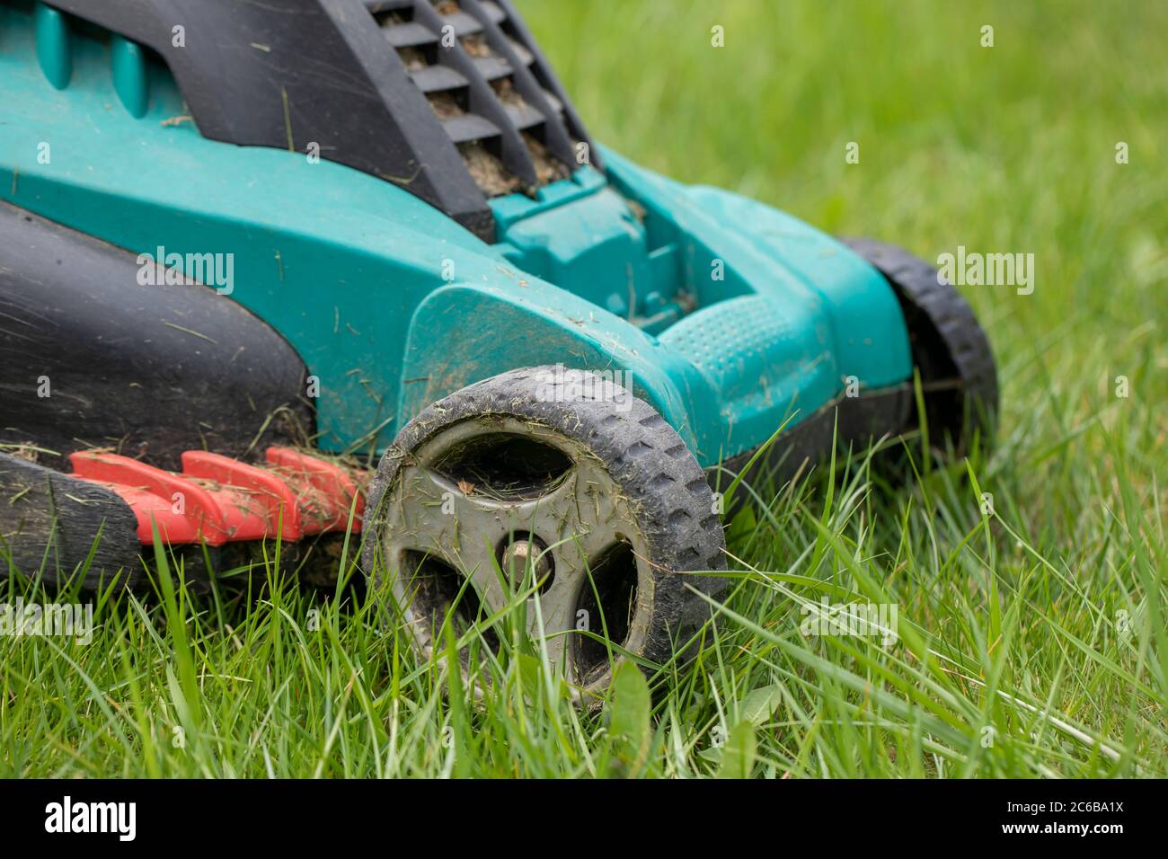 dirty lawn mower stands in stems of green grass Stock Photo - Alamy